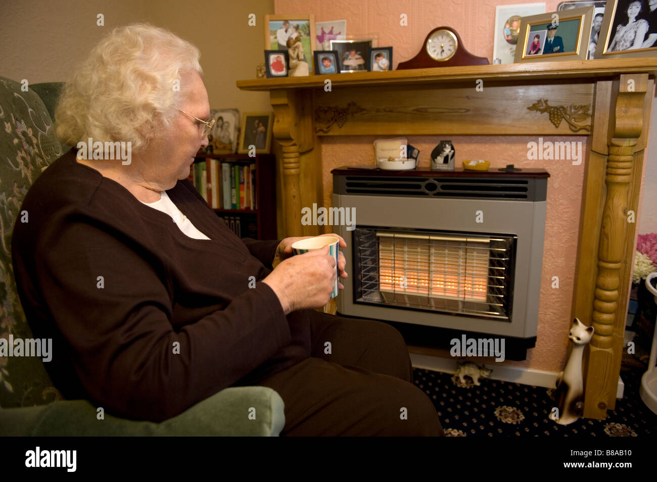 Old woman by electric fire hi-res stock photography and images - Alamy
