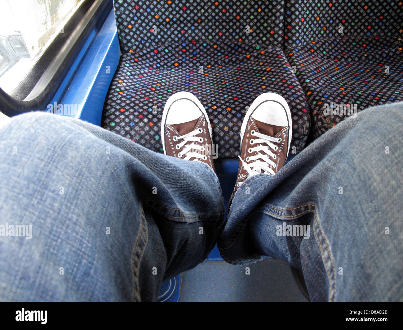 Feet resting on bus seat Stock Photo - Alamy