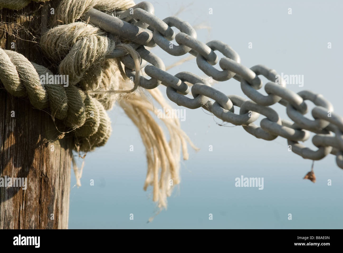 Chain attached to wooden post Stock Photo - Alamy