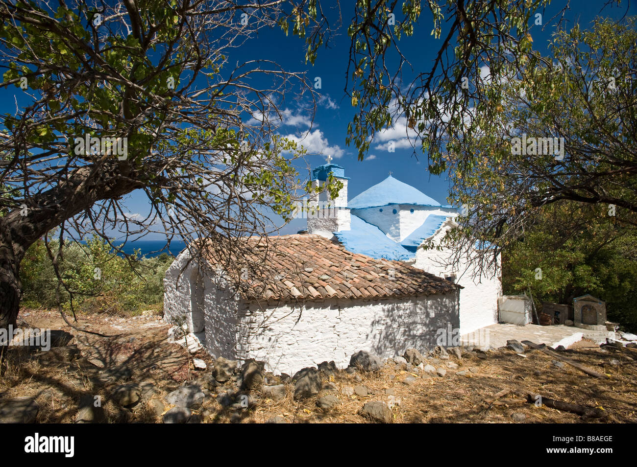 Greek chapel under a blue sky and green trees Stock Photo - Alamy