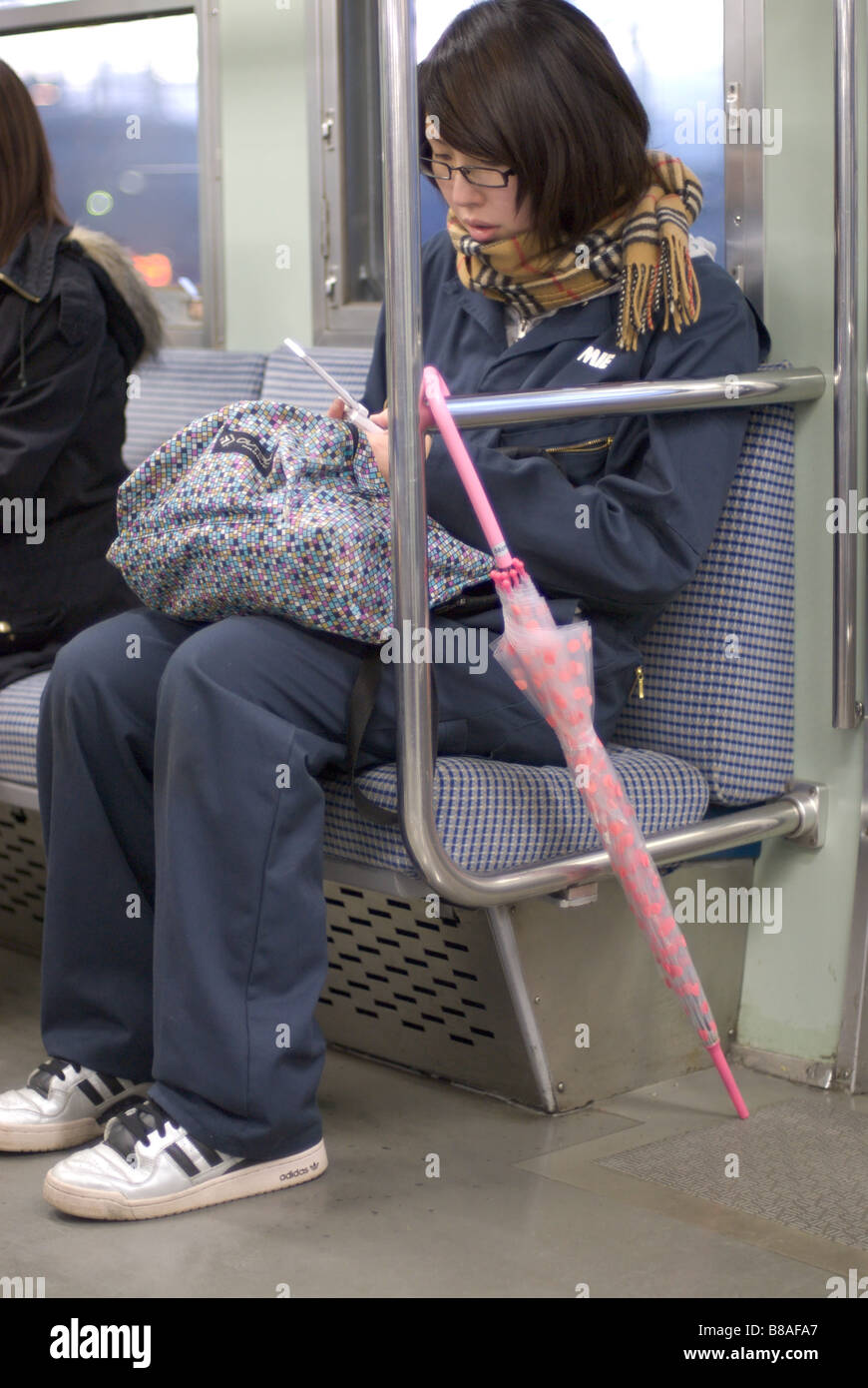 Japanese commuter using a mobile phone on a train Stock Photo - Alamy