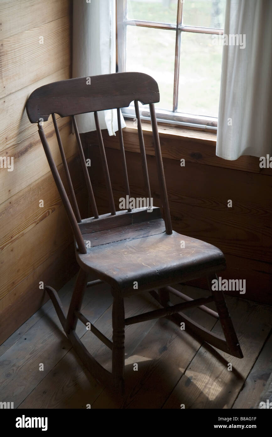 Photograph of a wooden rocking chair in front of a window Stock Photo ...