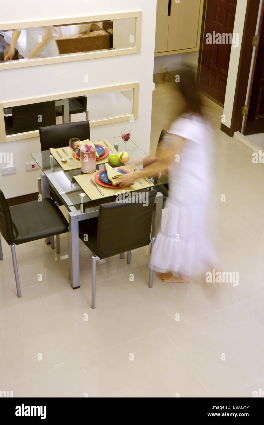 Young woman by dinning table Stock Photo - Alamy