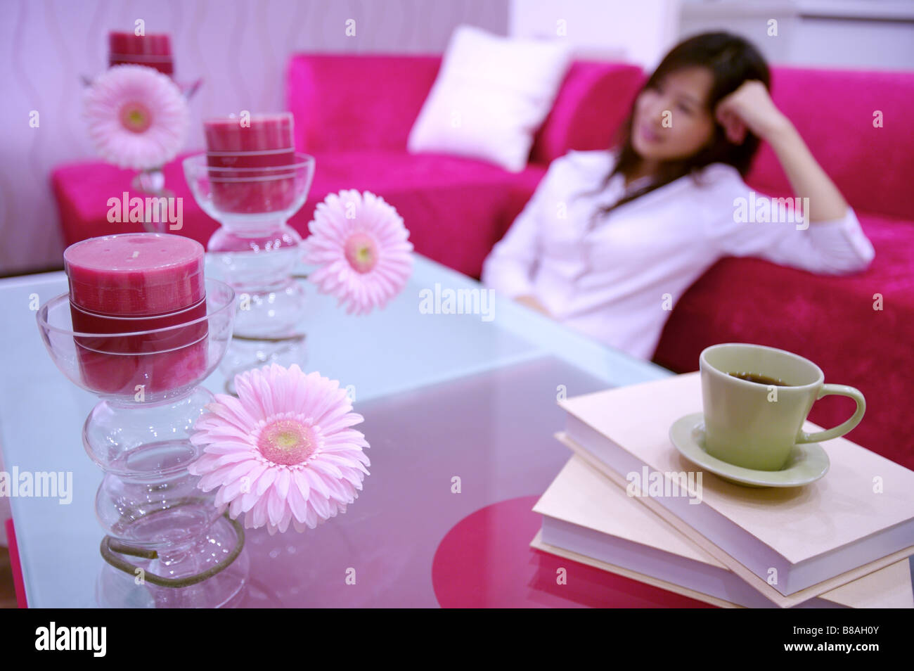 Young woman reclining by sofa in living room Stock Photo - Alamy