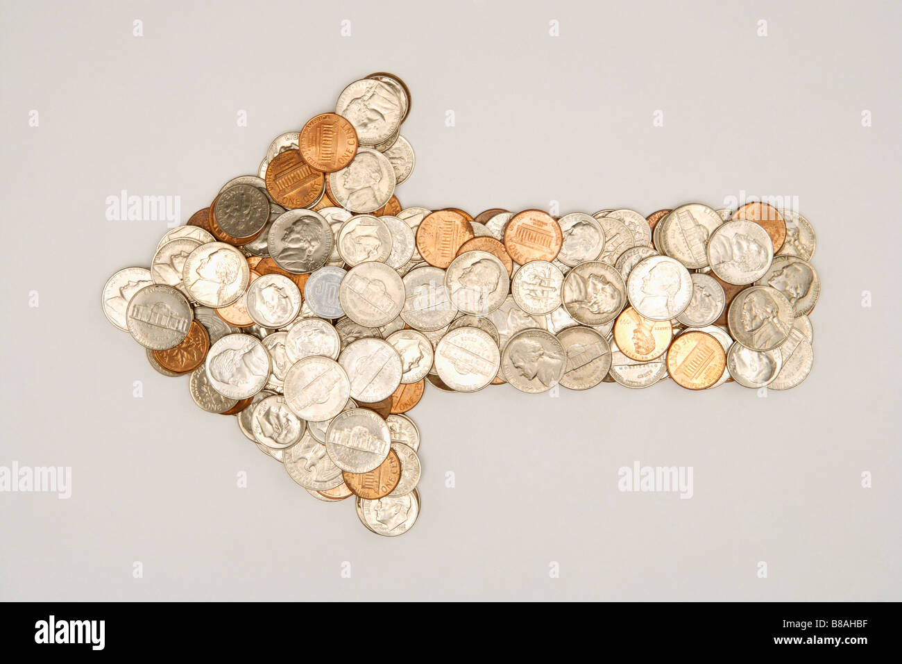 Coins in shape of arrow sign Stock Photo - Alamy