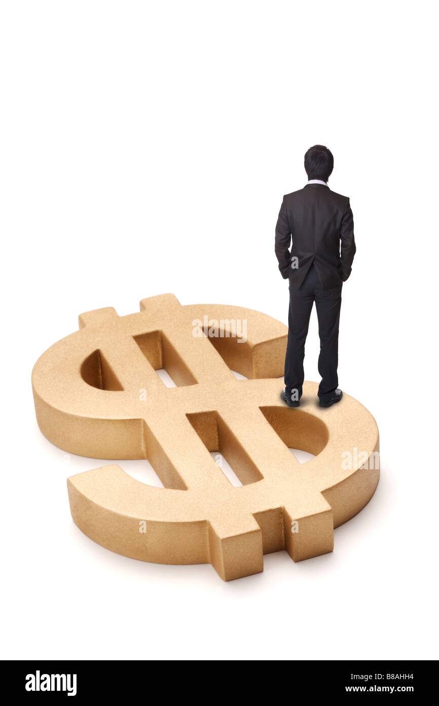 Man standing on big dollar sign Stock Photo - Alamy