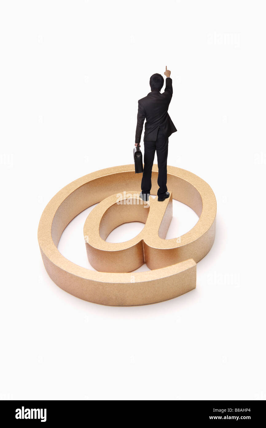 Businessman standing on big symbol Stock Photo - Alamy