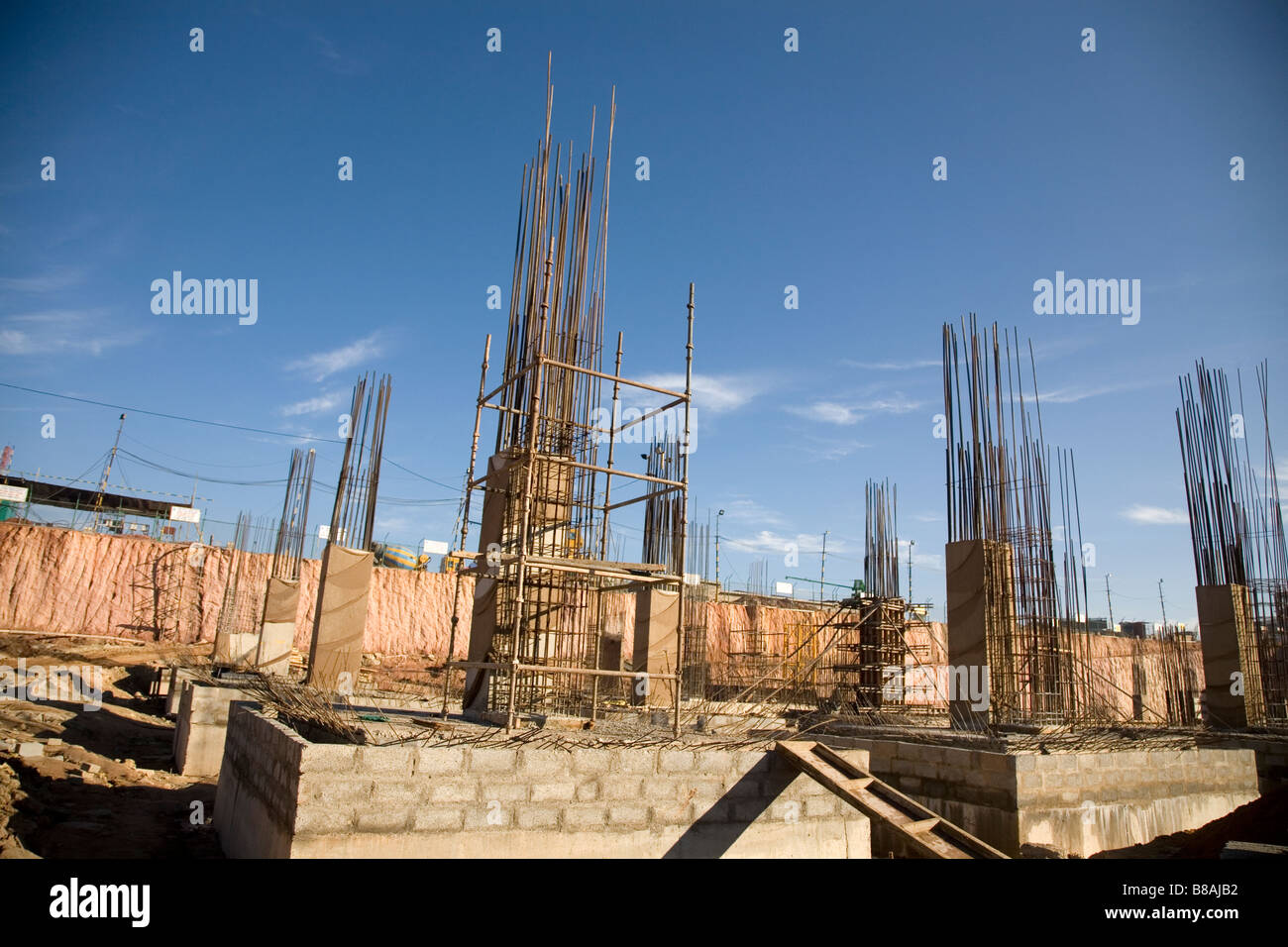 The steel rods of a construction site's foundations stand in concrete ...