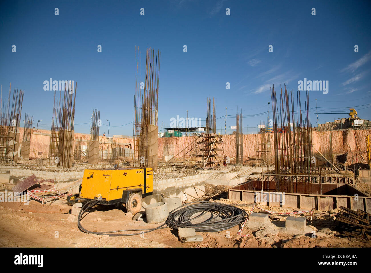 The steel rods of a construction site's foundations stand in concrete ...