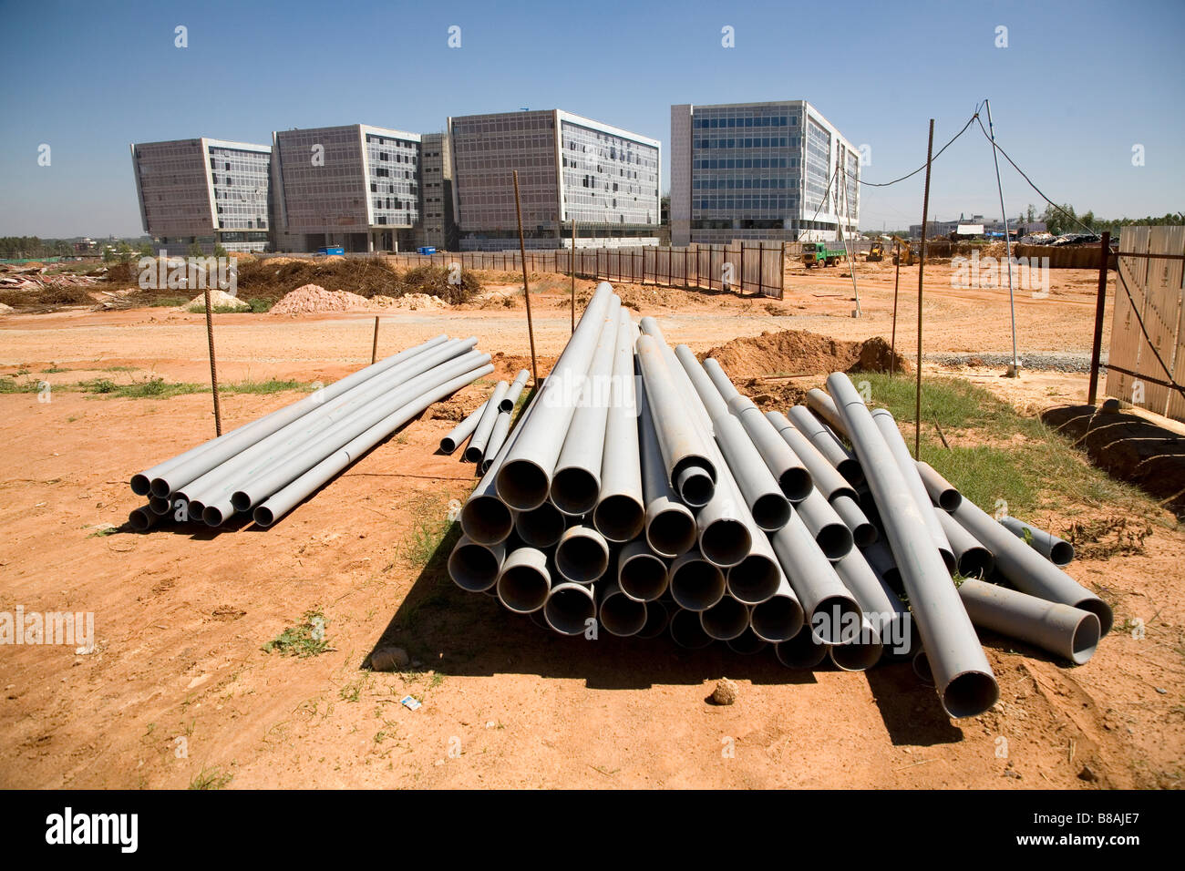 Pipes stand ready to be installed on a building site in Bangalore ...