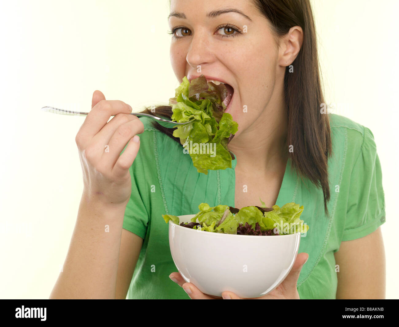 Young Woman Eating Freshly Prepared Healthy Green Salad With A Clipping ...