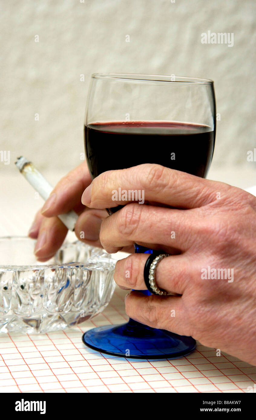 Woman with a glass of red wine and smoking a cigarette Stock Photo - Alamy