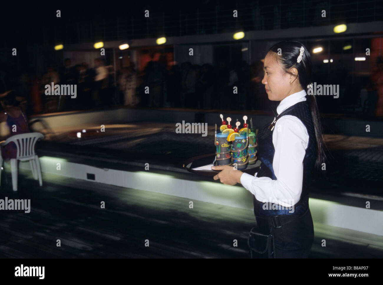 philipino waitress serving drinks on outside deck of a cruise ship ...