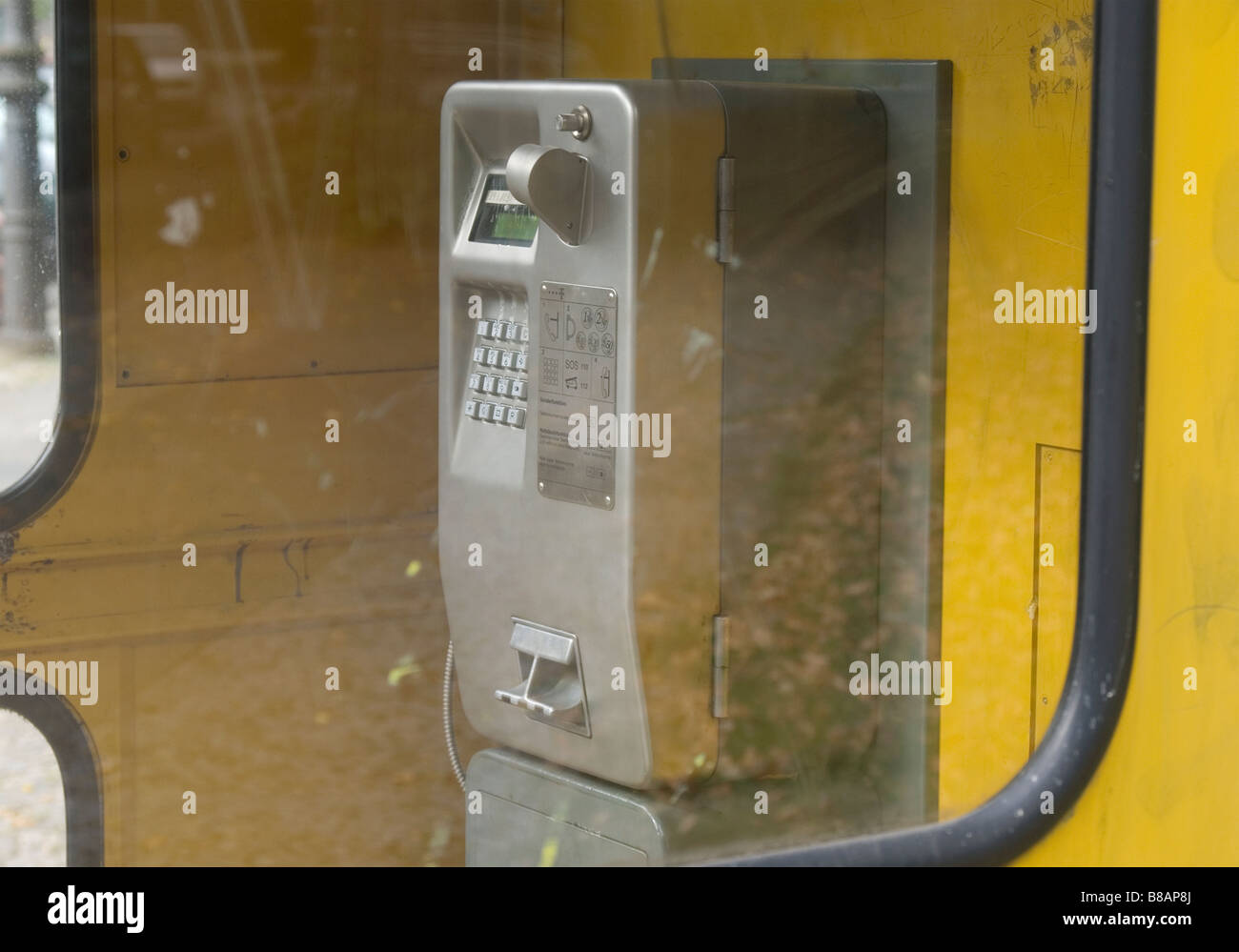 public telephone through the glass Stock Photo - Alamy