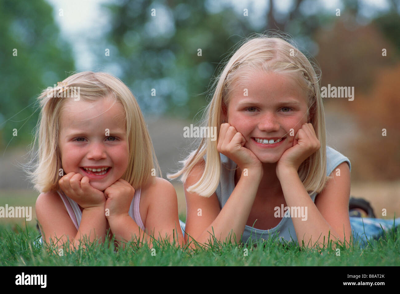 FV3418, Trevor Bonderud; Blonde Sisters Lying Grass, Leaning Hands ...