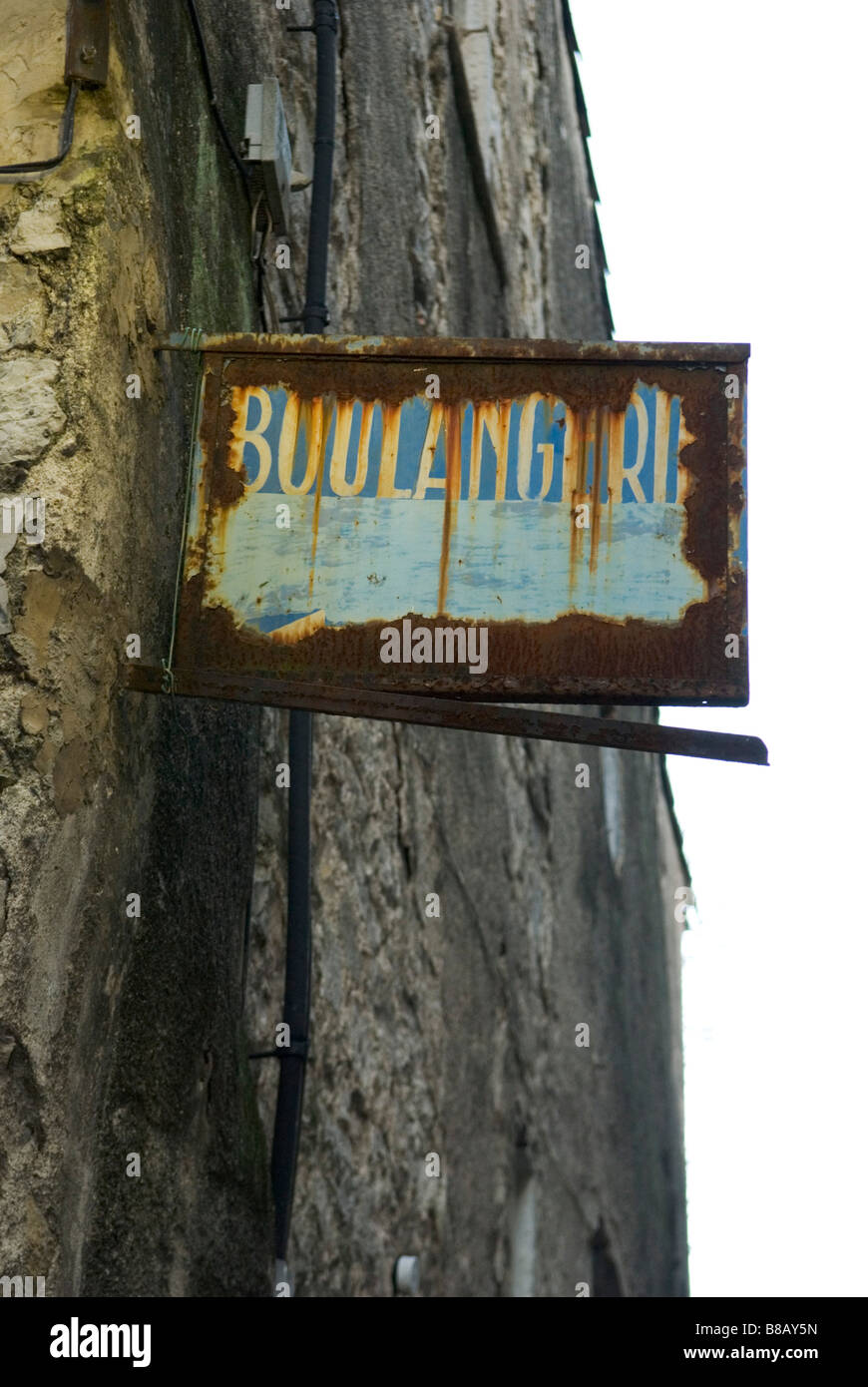 looking up at an old rusting boulangerie sign on medieval building ...