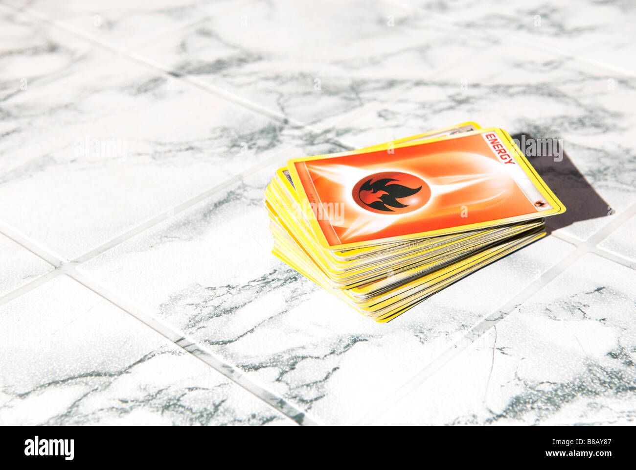 a child's pack of pokemon cards showing 'energy' value on outdoor table ...