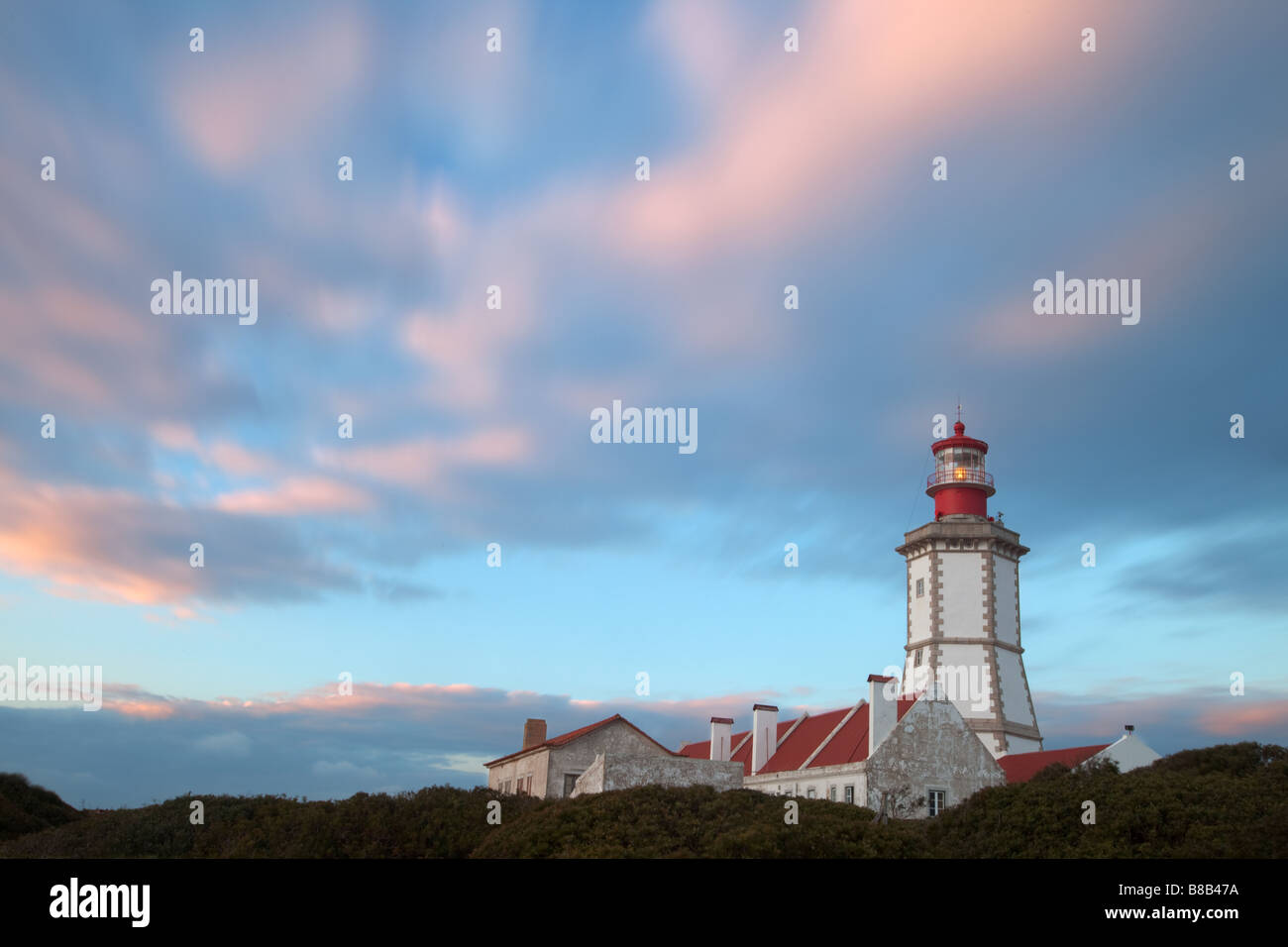 Espichel Lighthouse at sunset with pink clouds and blue sky, Espichel Cape, Sesimbra, Portugal ...