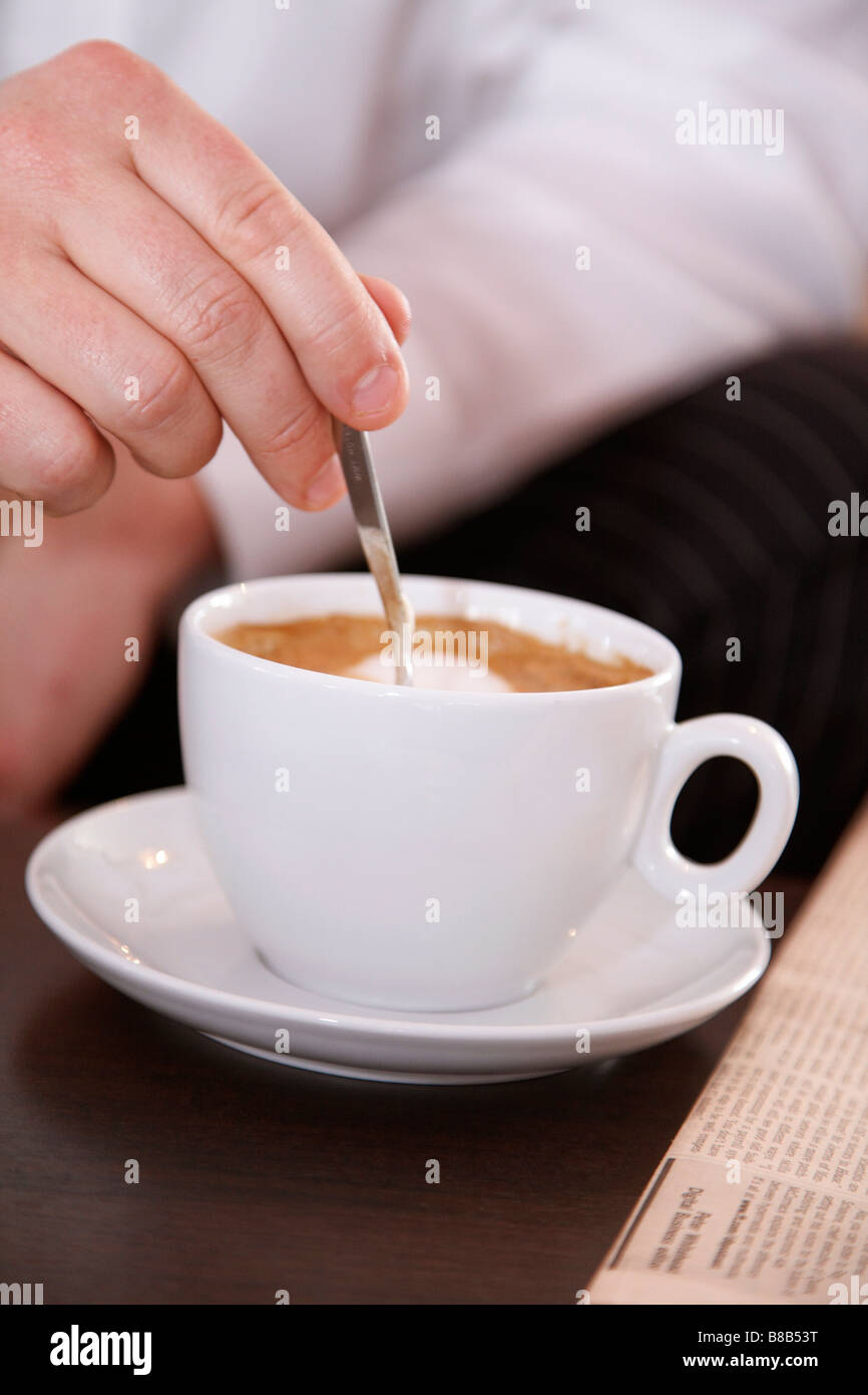 Man stirring a cup of coffee Stock Photo - Alamy