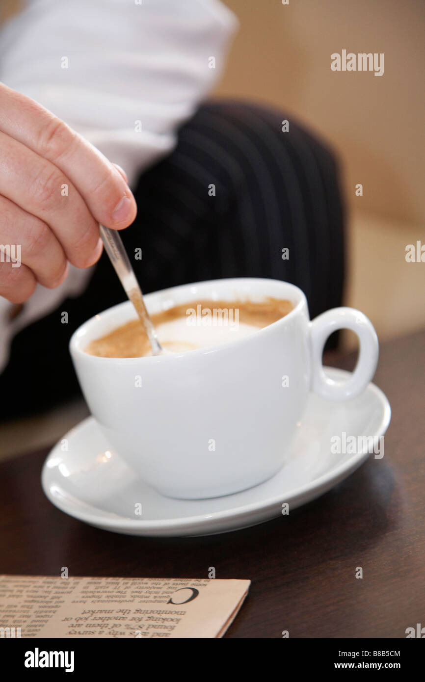 Man stirring a cup of coffee Stock Photo - Alamy