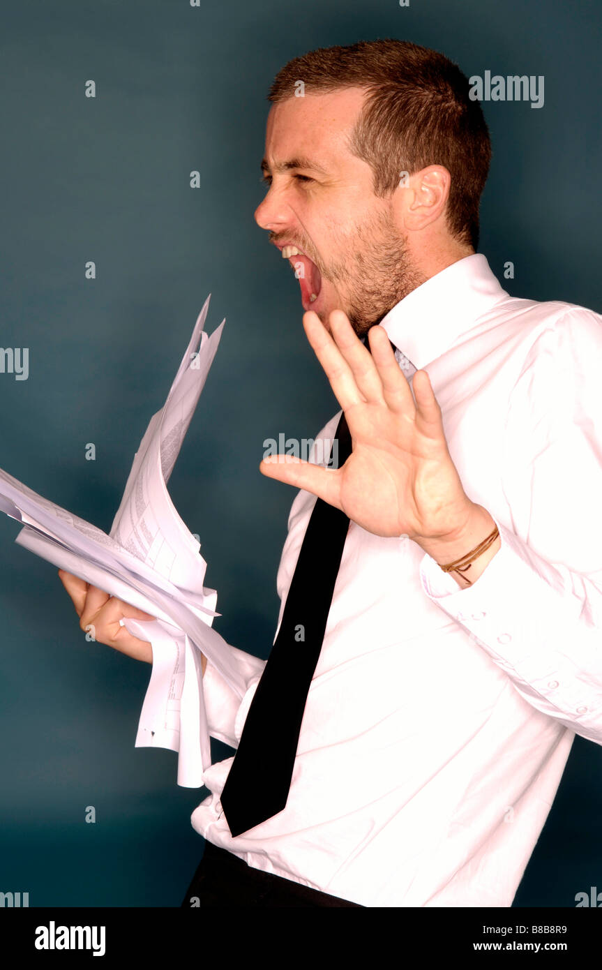 a businessman holding papers confused and angry Stock Photo - Alamy