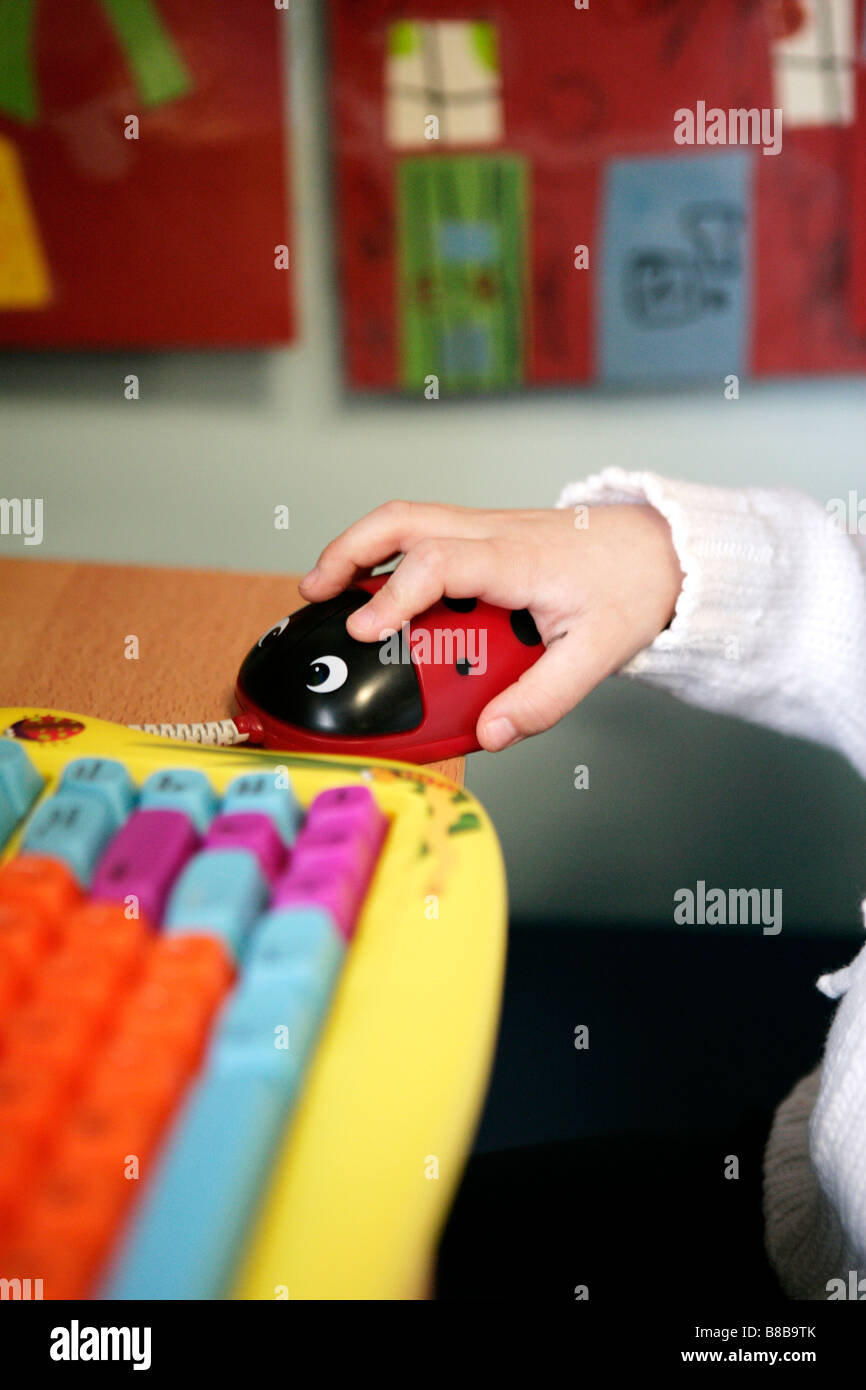 girl in primary school using computer mouse shaped like a ladybird ...