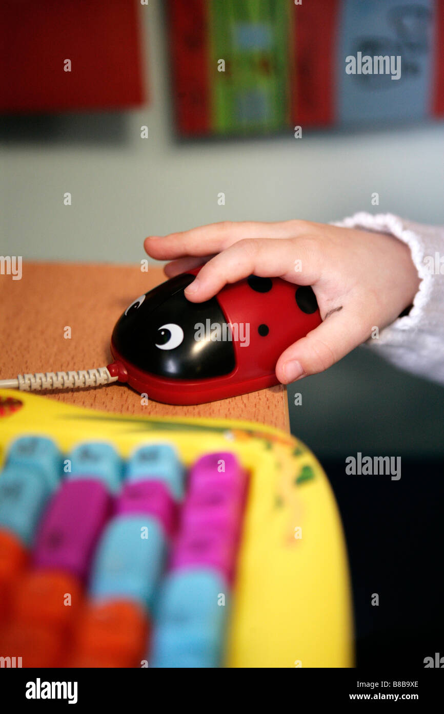 girl in primary school using computer mouse shaped like a ladybird ...