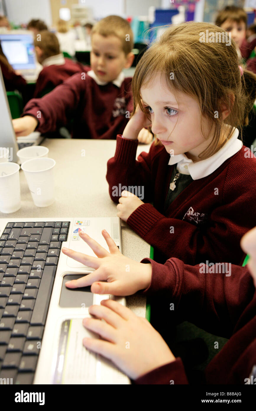primary school pupils working with laptop computer in classroom Stock ...