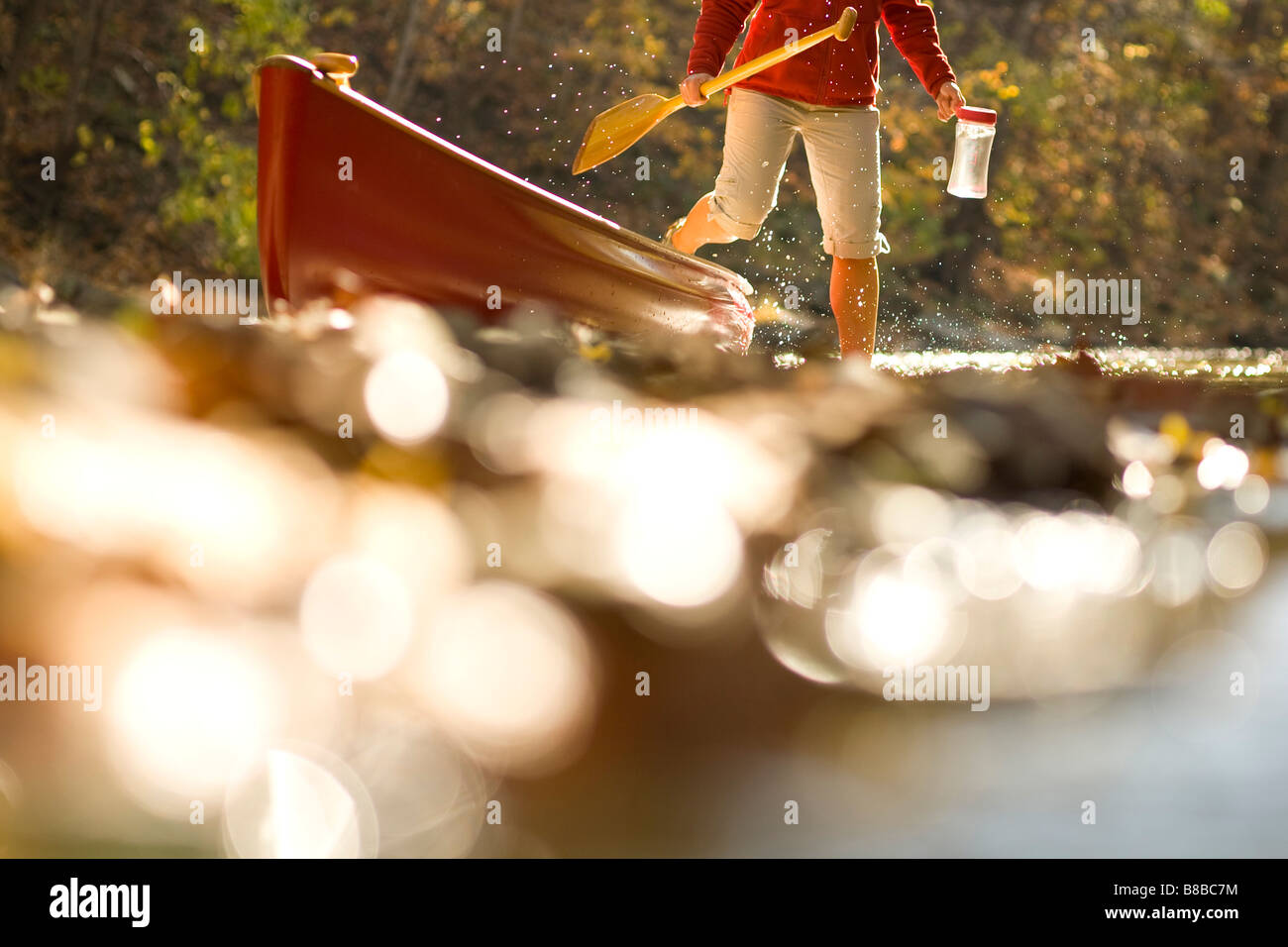 Woman stepping out of canoe in the river Stock Photo - Alamy