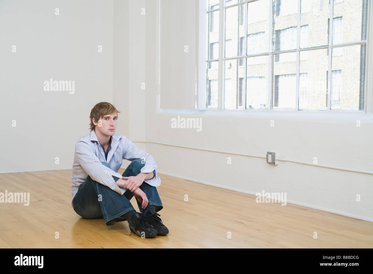 Man Sitting Floor an Empty Room Stock Photo - Alamy