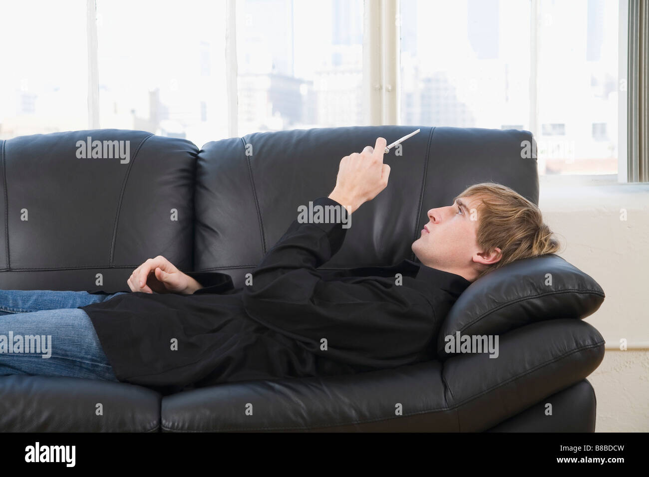 Man Laying Couch Holding Cell Phone Stock Photo - Alamy