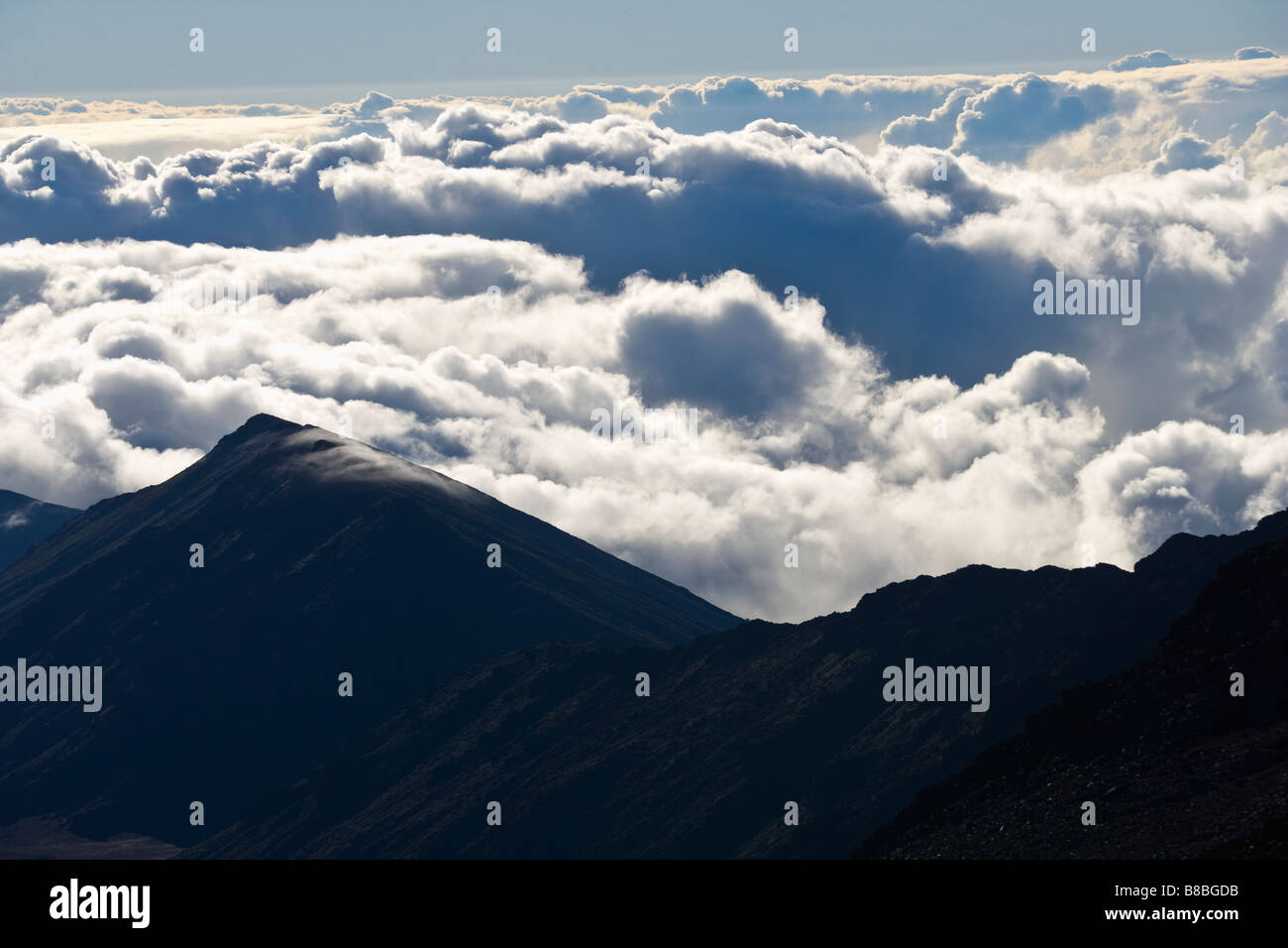 A mountain ridgeline on Haleakala with clouds swirling below, Maui ...