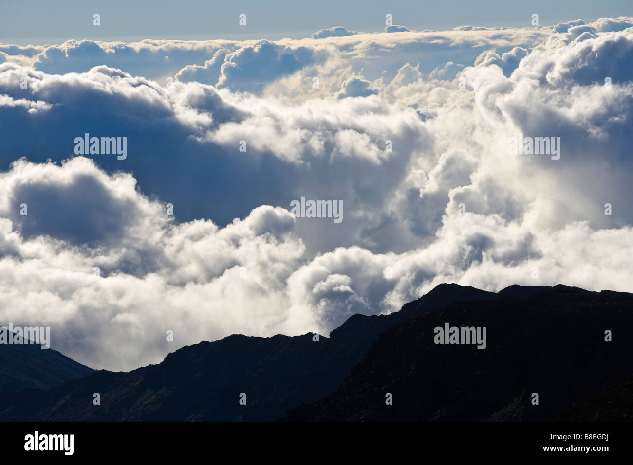 A mountain ridgeline on Haleakala with clouds swirling below, Maui ...