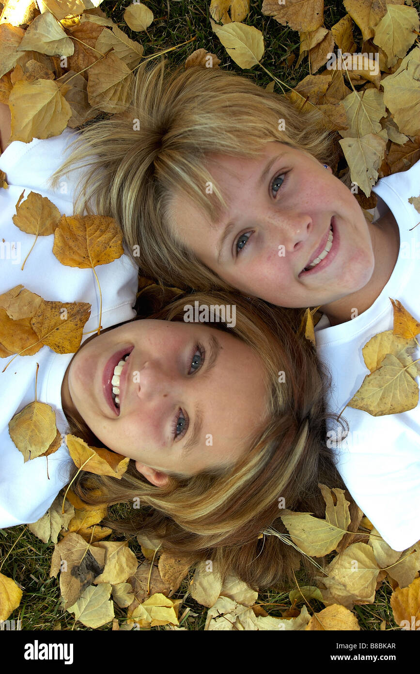 Sisters Laying Autumn Leaves Stock Photo - Alamy