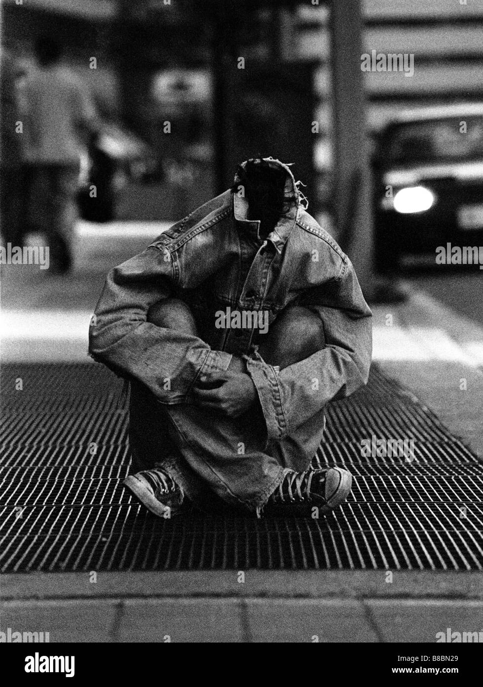 FL3020, HUY LAM; Headless person sitting crossed legged above sidewalk ...