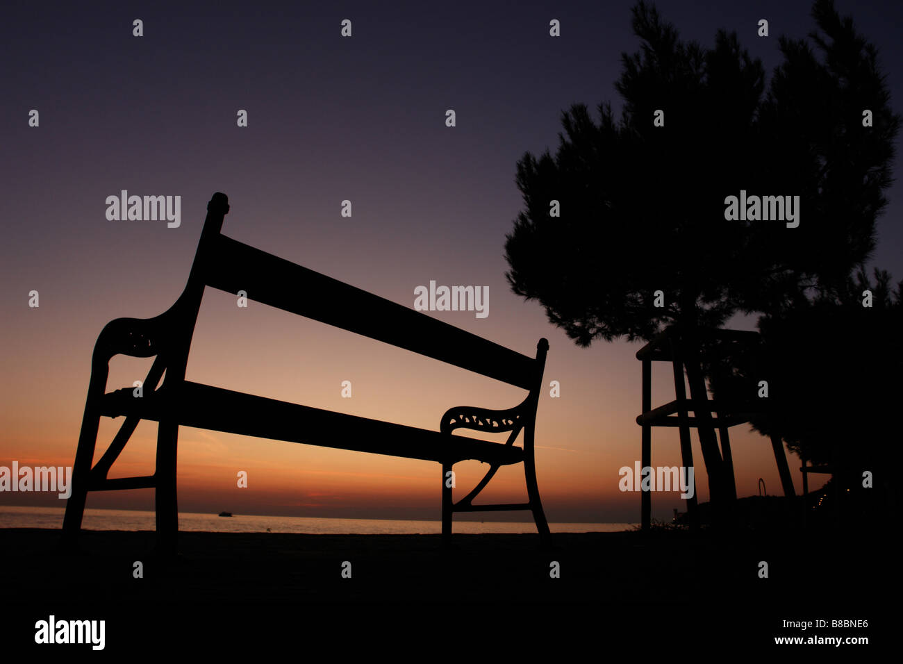 a bench at the sea at sunset Stock Photo - Alamy