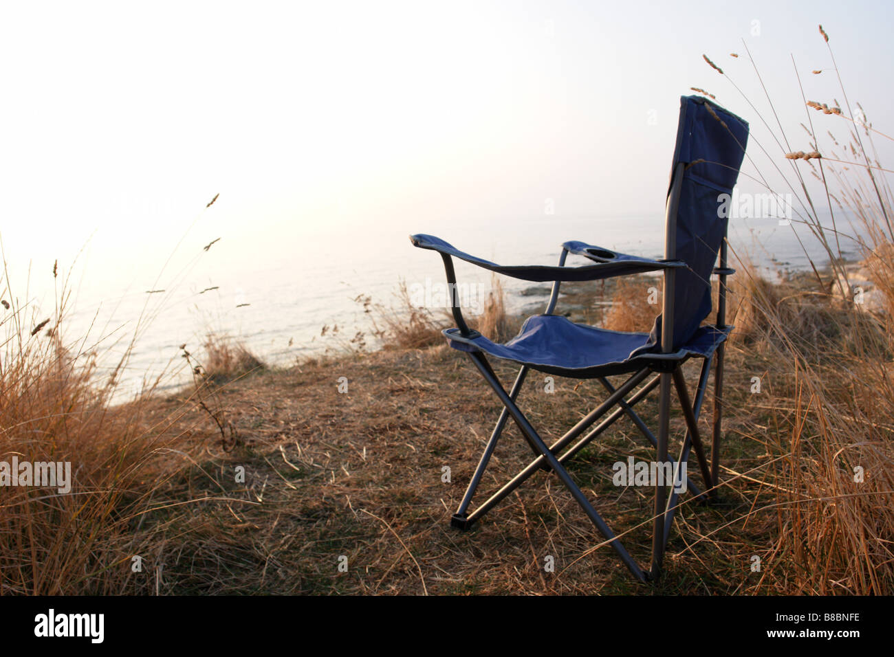 a chair at the sea at sunset Stock Photo - Alamy