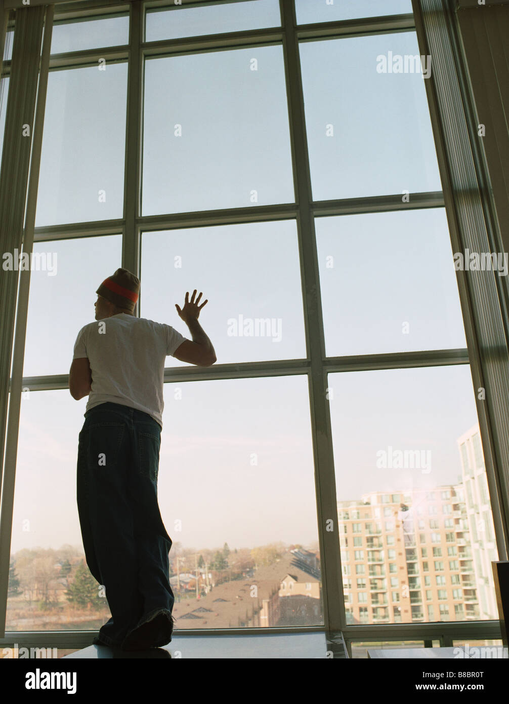 Young Man leaning against Window Stock Photo - Alamy