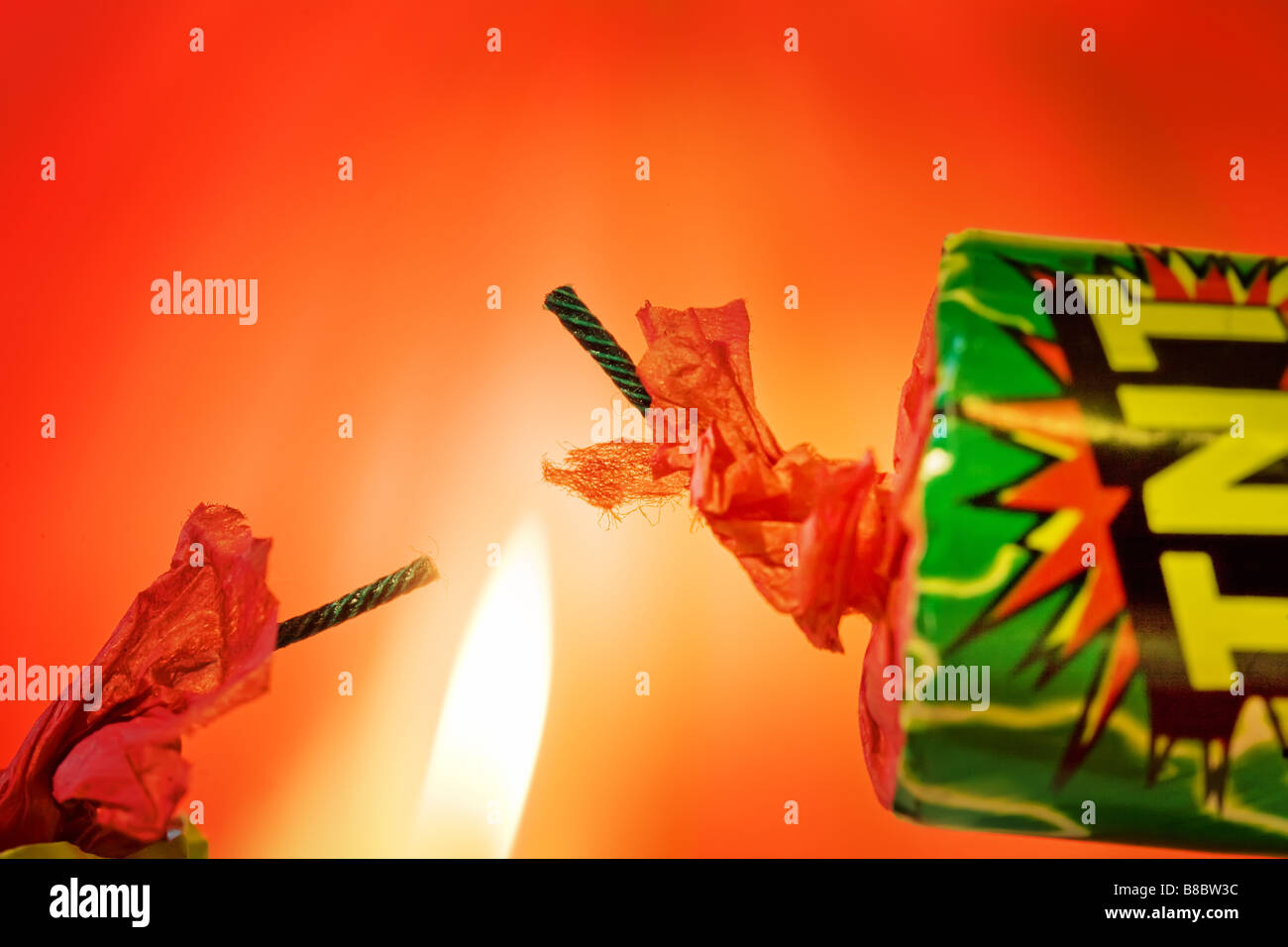 two fireworks being lit by a match or flame Stock Photo - Alamy