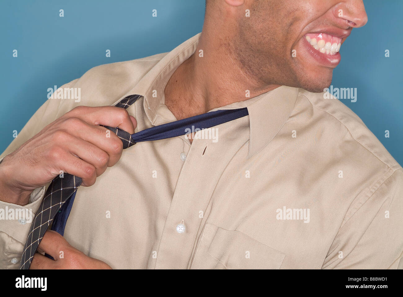 Young Businessman Pulling Tie Stock Photo - Alamy