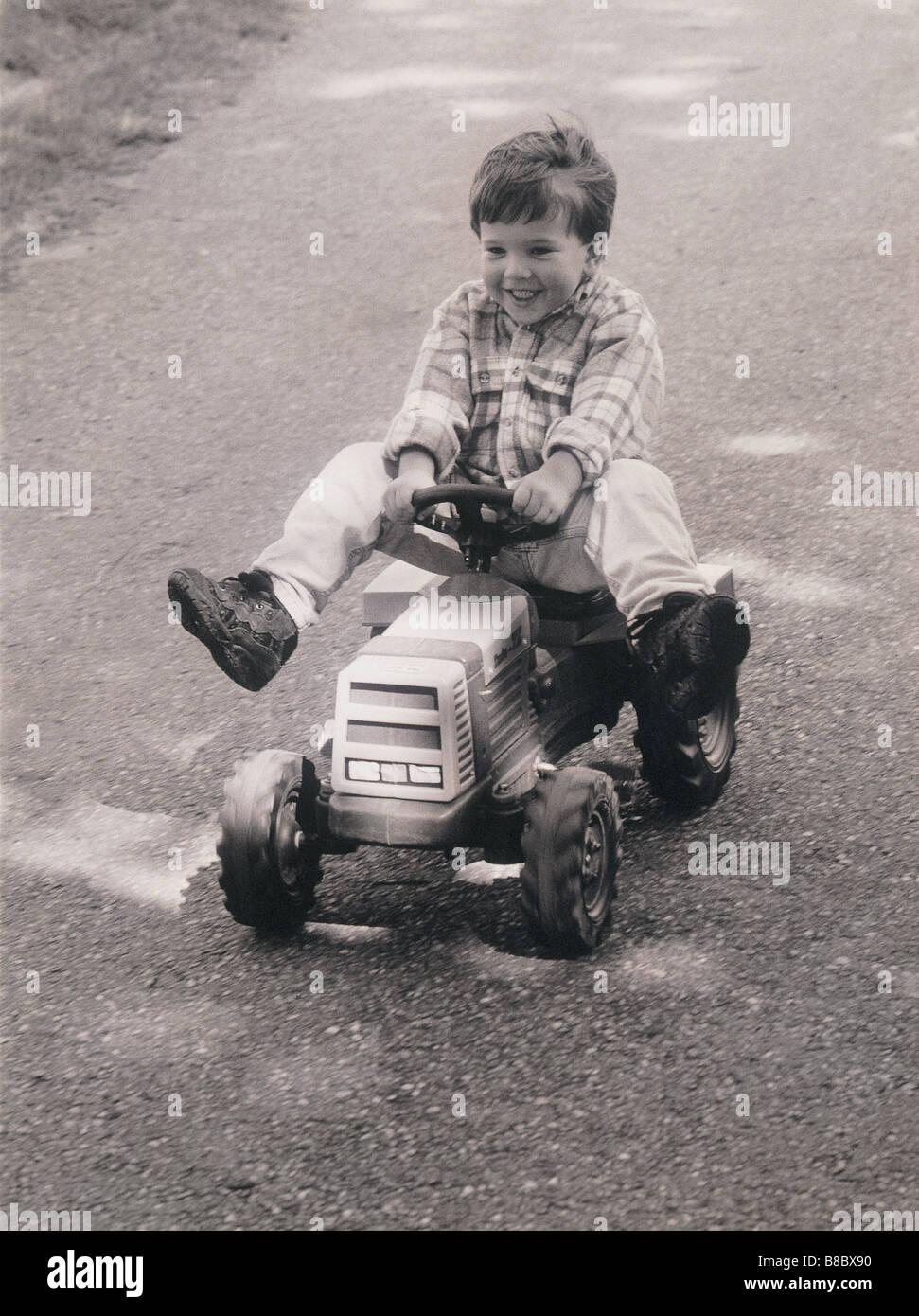 FL4952, Matthew Plexman; Happy Boy Riding Toy Tractor, BW Stock Photo ...
