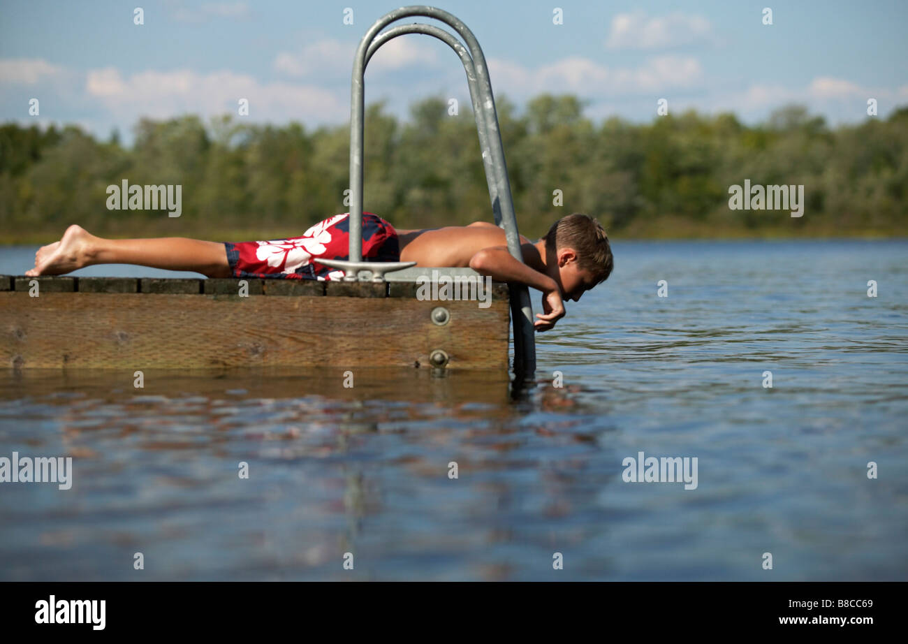 Boy Looking into Water f Edge Dock Stock Photo - Alamy