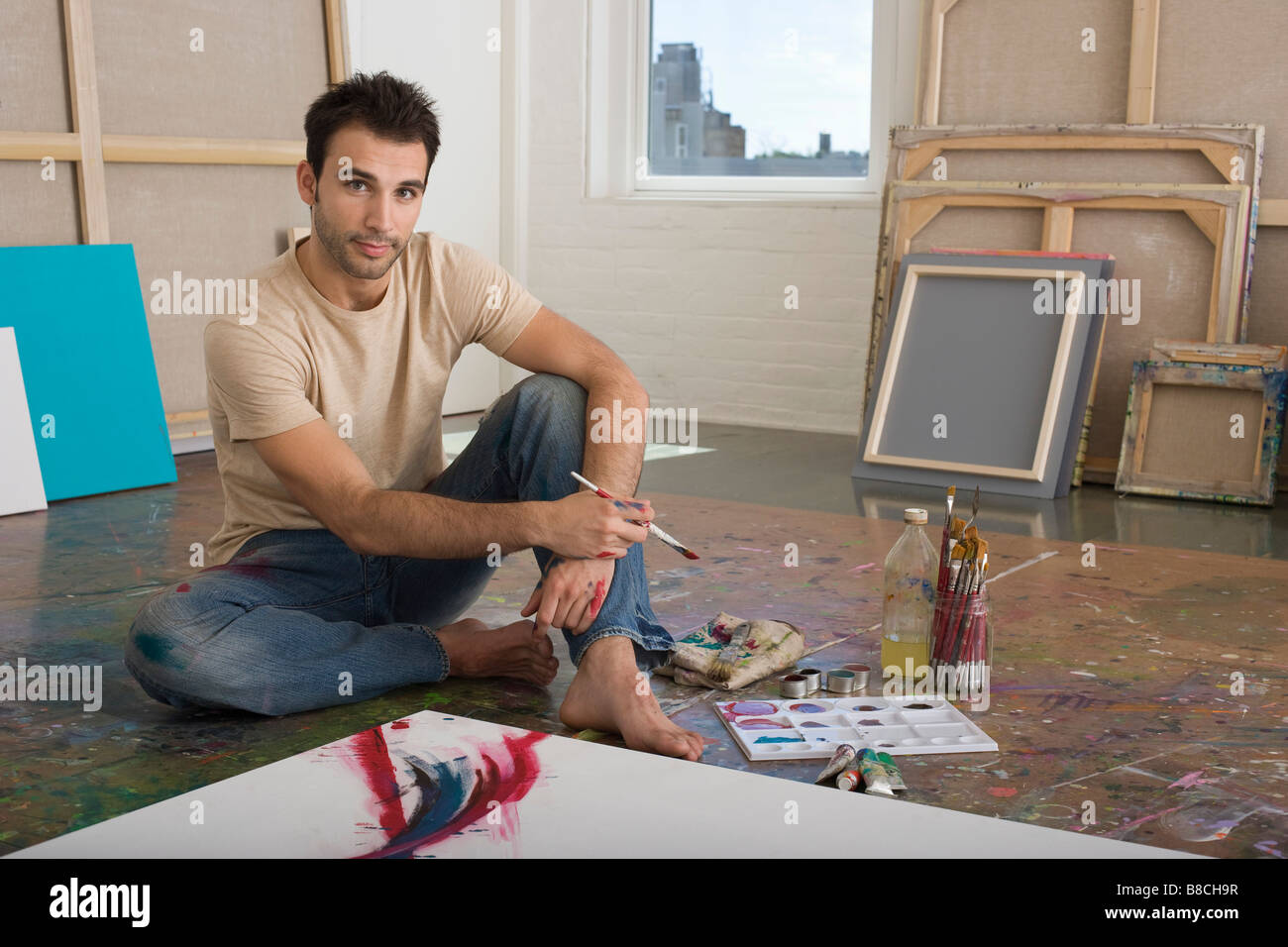Artist Working on Canvas on Floor of Studio Stock Photo - Alamy