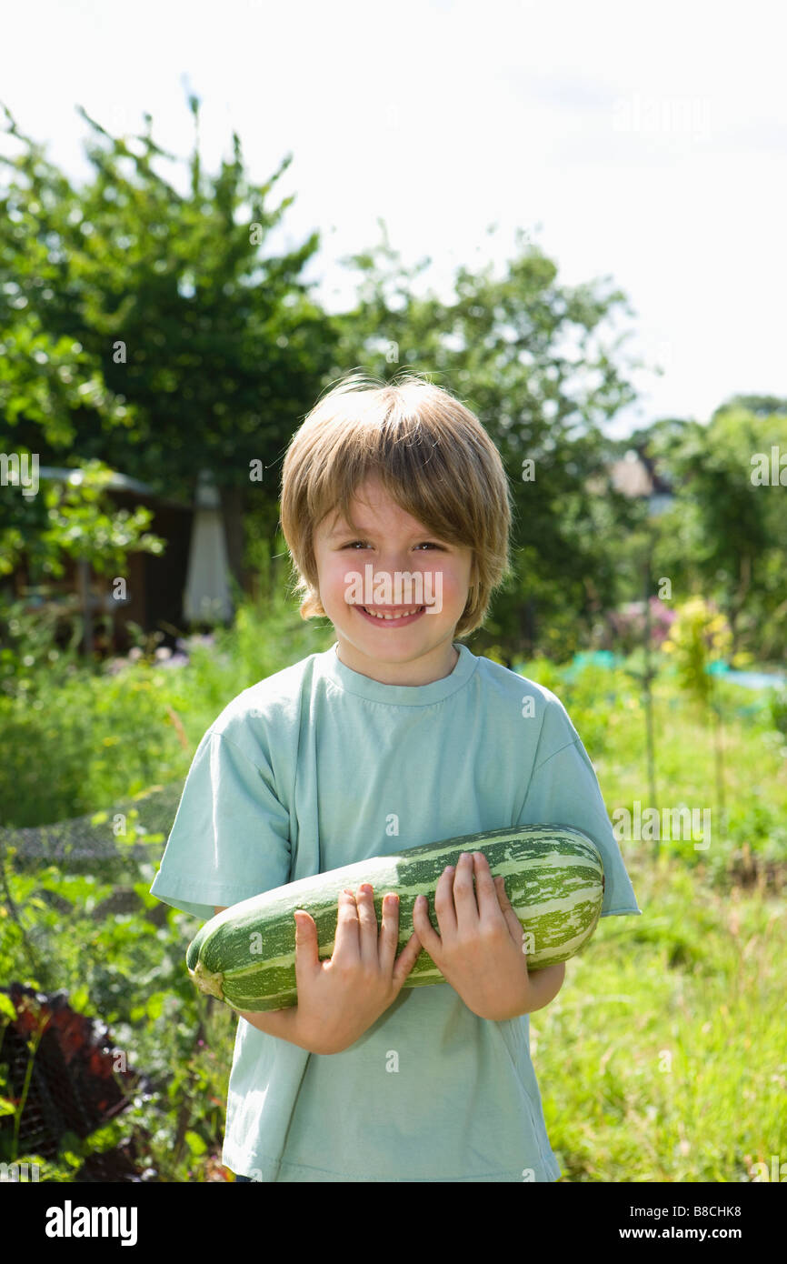 Boy holding marrow in garden, portrait Stock Photo - Alamy