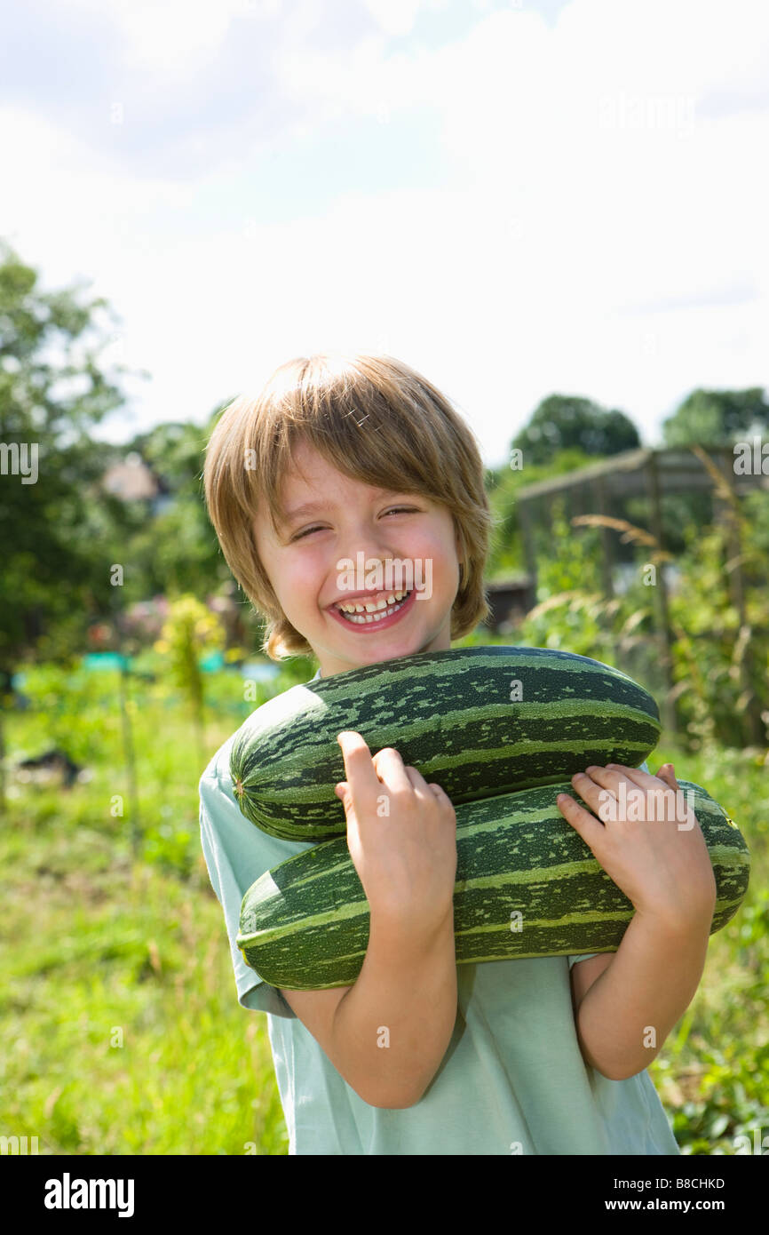 Boy holding marrow in garden, portrait Stock Photo - Alamy