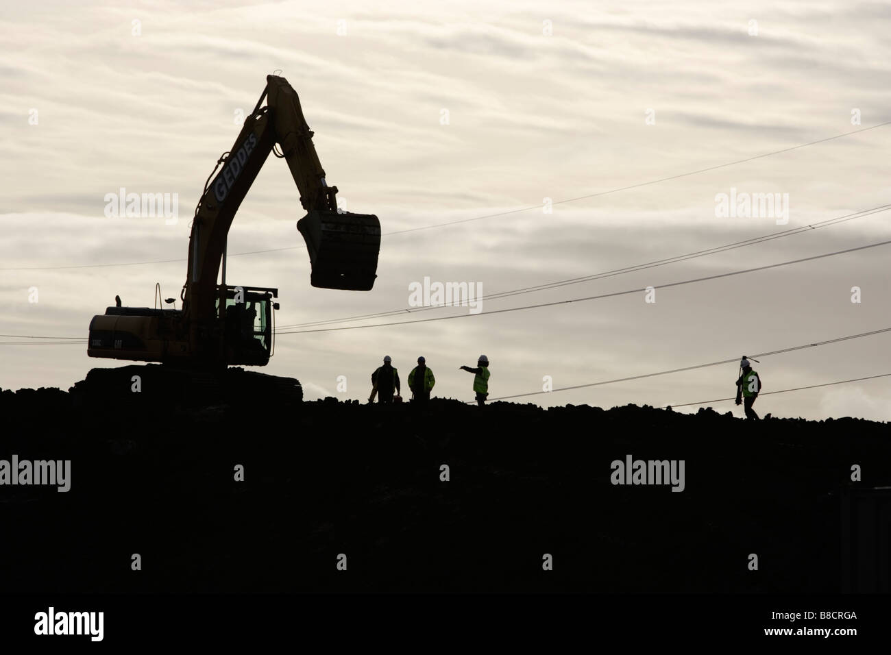 Workers and a digger Stock Photo - Alamy