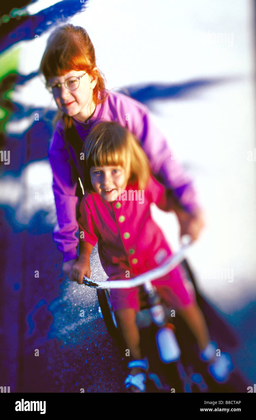 FV0544, Trevor Bonderud; Two girls riding tricycle Stock Photo - Alamy