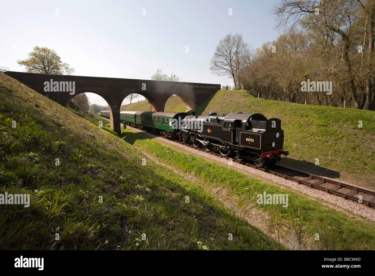 Steam engine passing bridge on the Bluebell Railway Stock Photo - Alamy