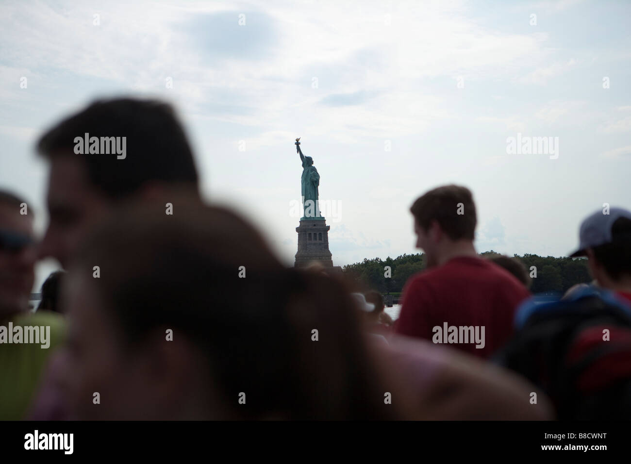 crowd of tourists near the statue of liberty visiting and takeing ...