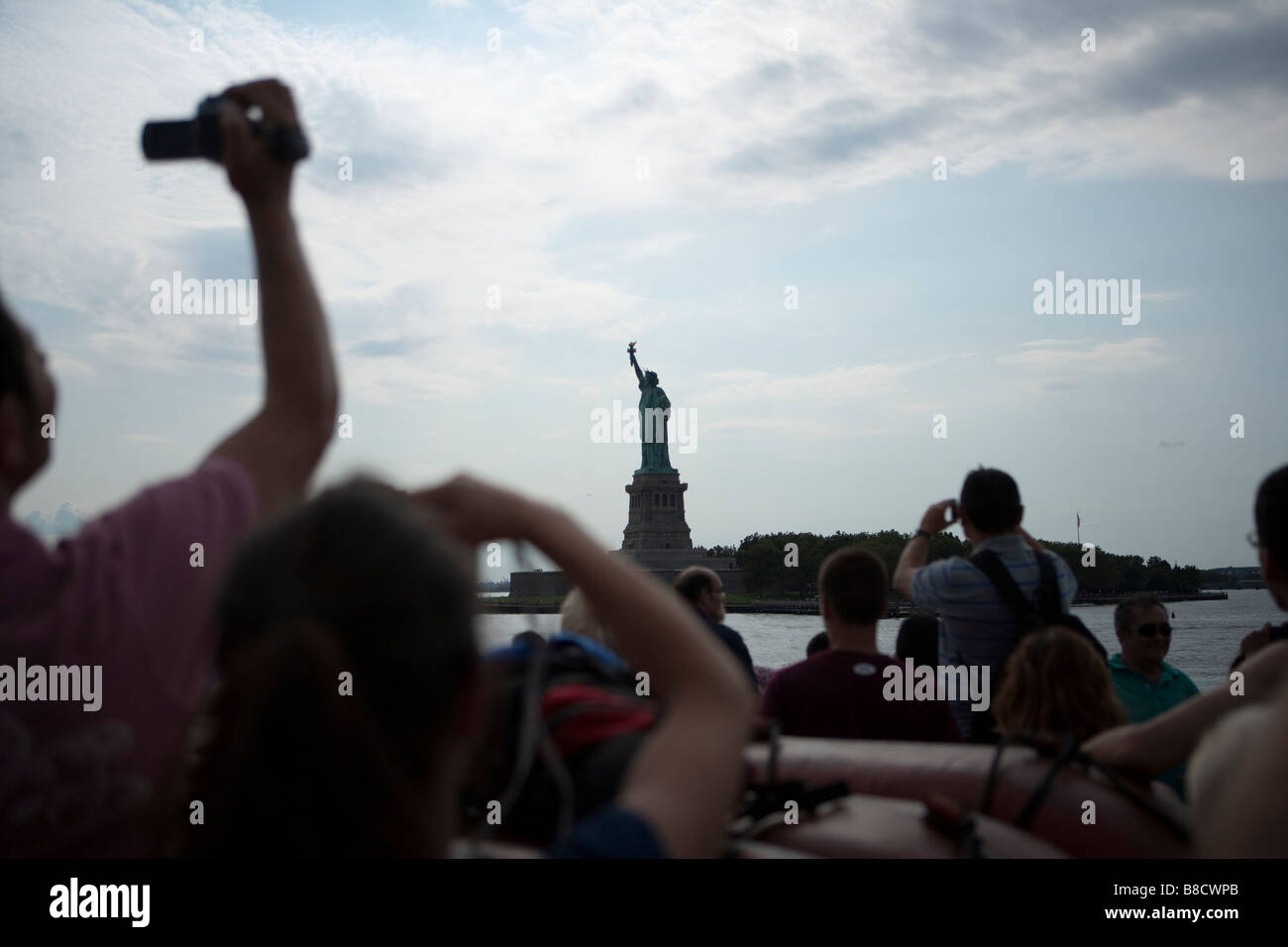 crowd of tourists near the statue of liberty visiting and takeing ...